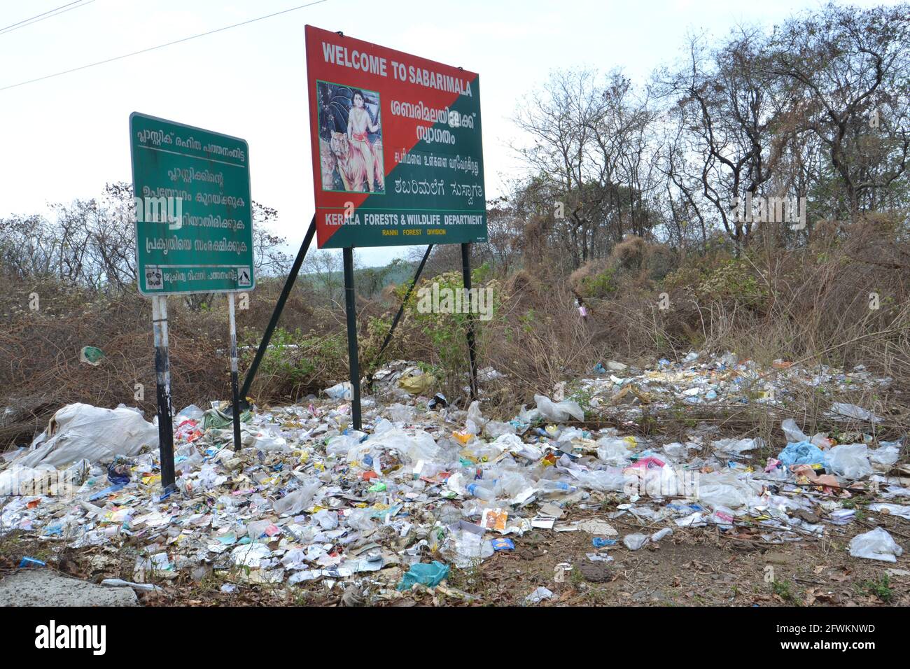 waste disposed in forest in front of board Stock Photo - Alamy