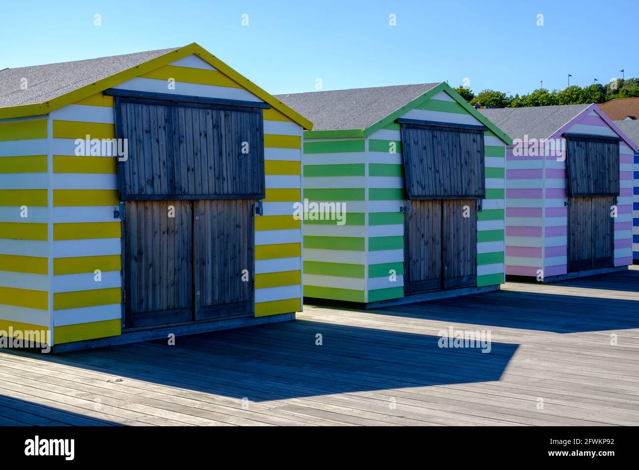 Staycation idea. Close up of colourful striped beach hut style stalls ...