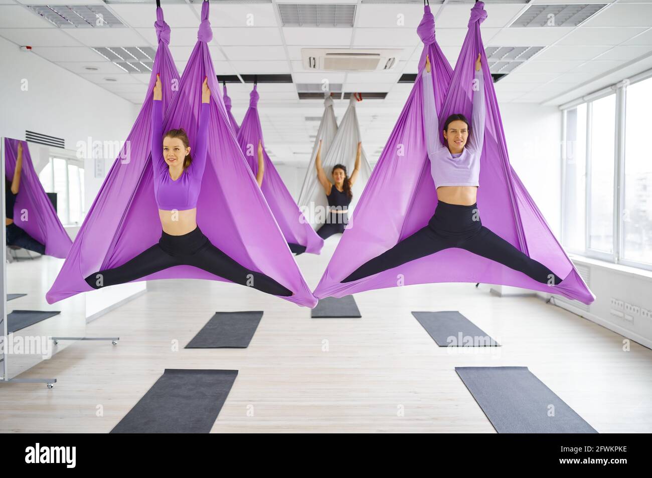 Fly yoga, female group hanging on hammocks Stock Photo - Alamy