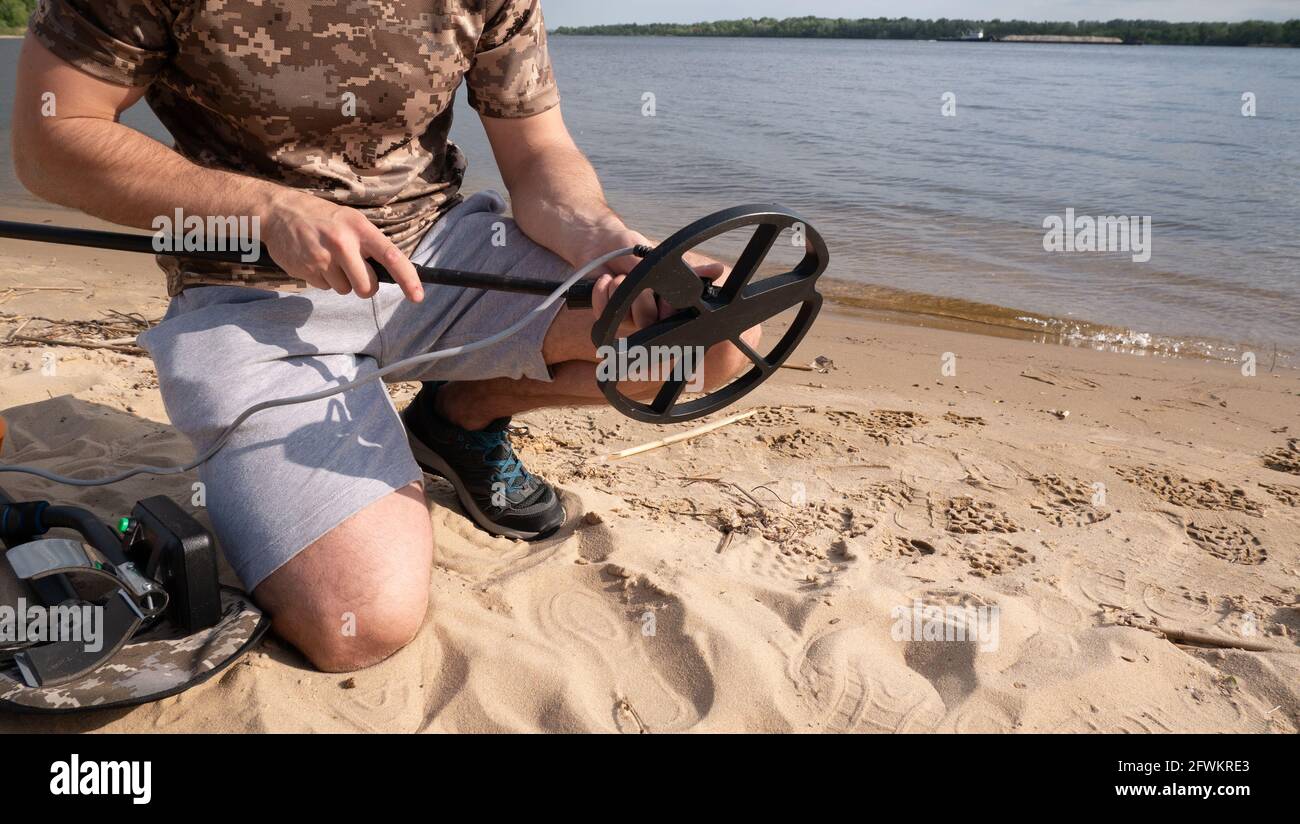 Men on the shore getting ready for a treasure hunt with a metal ...