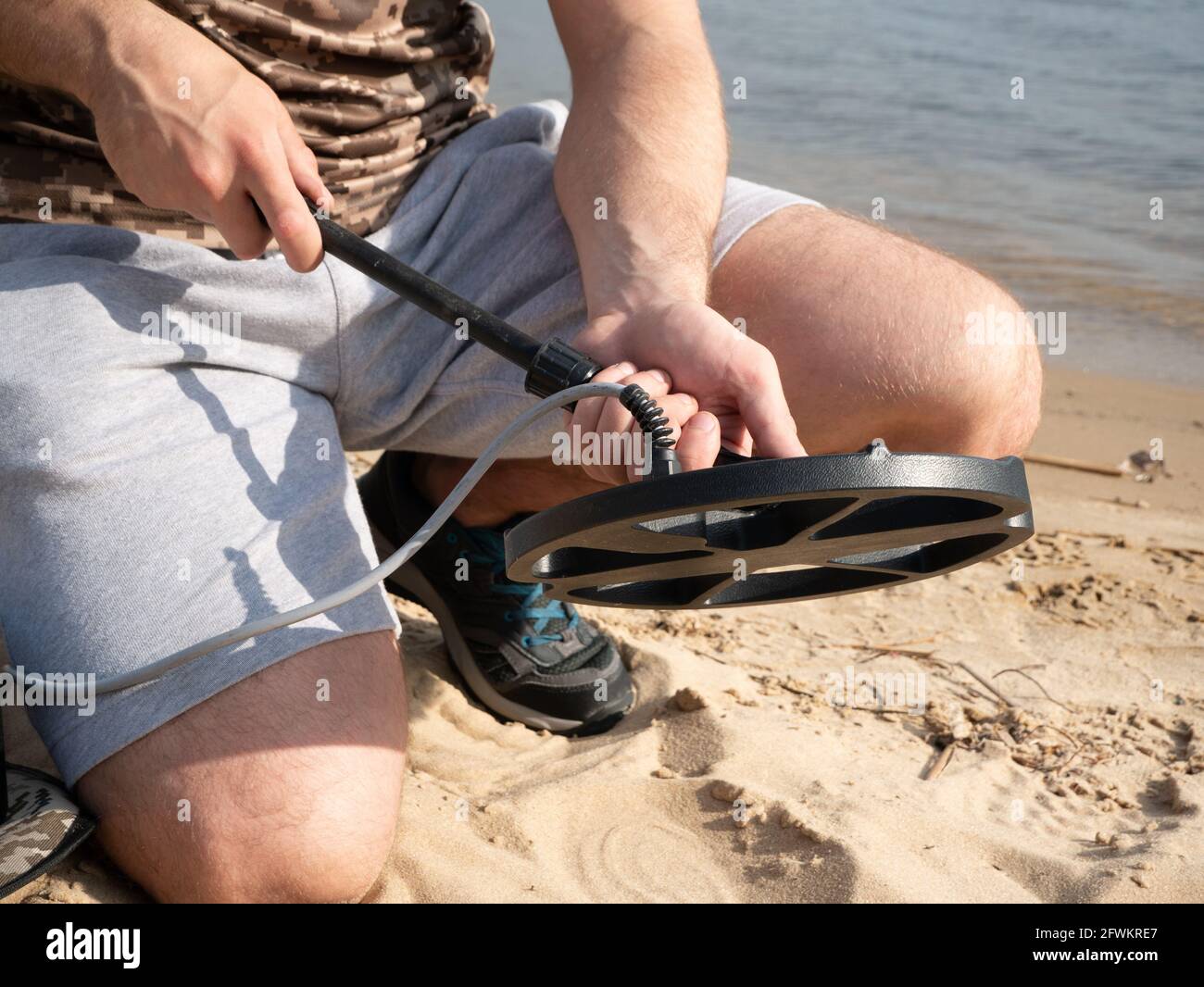 Men on the shore getting ready for a treasure hunt with a metal ...