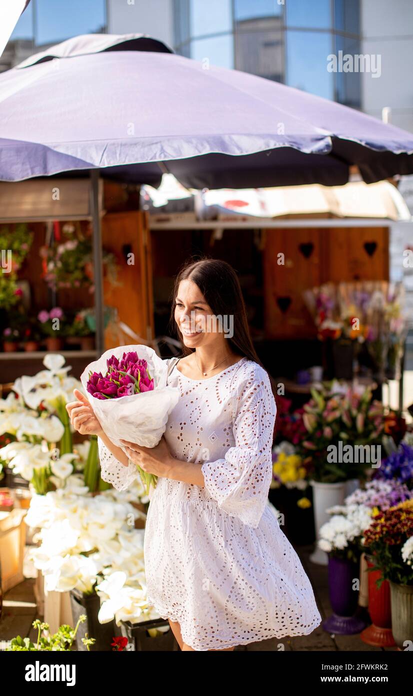 Pretty young woman buying flowers at the flower market Stock Photo - Alamy