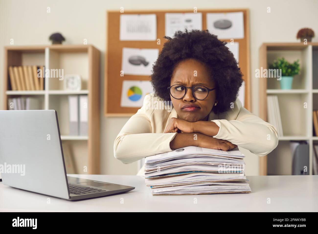 Young frowning busy african american woman employee sitting at office ...