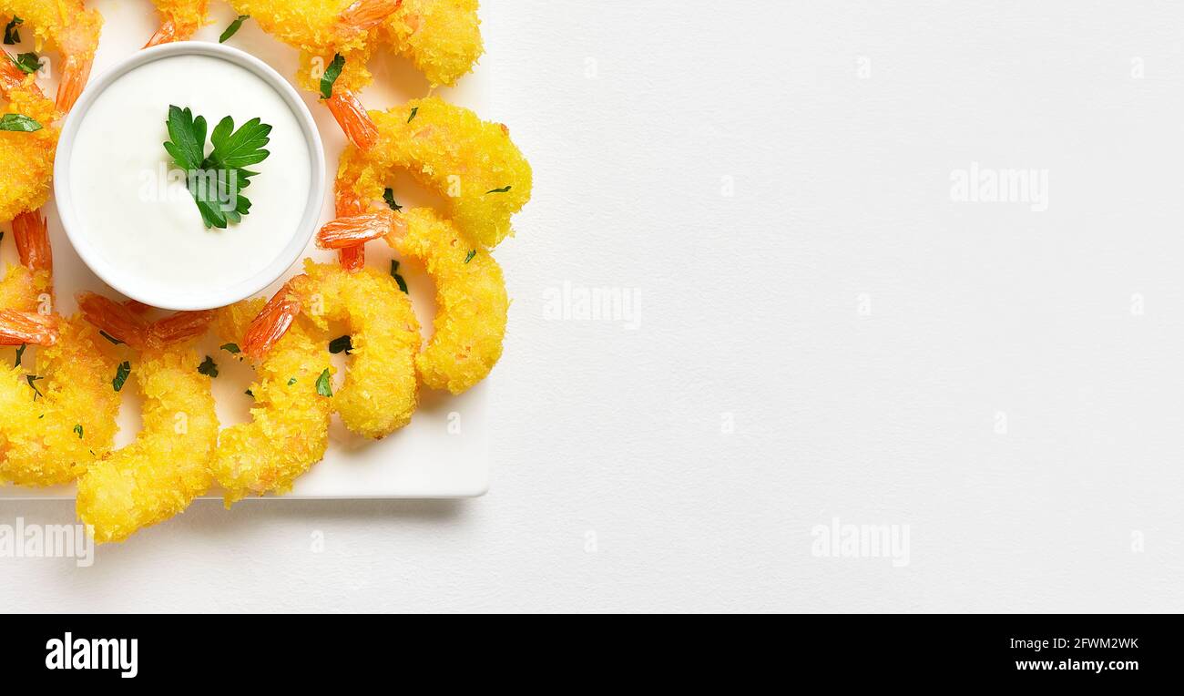 Close up view of deep fried breaded prawn on plate over white stone ...