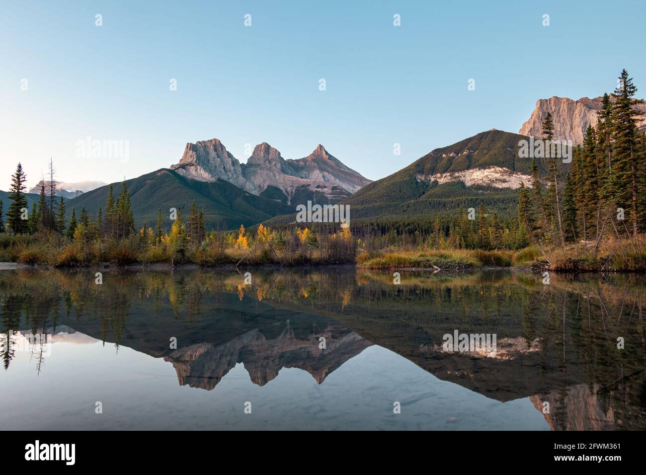 Three sisters mountains of rocky mountains reflection on bow river in the morning at Canmore ...