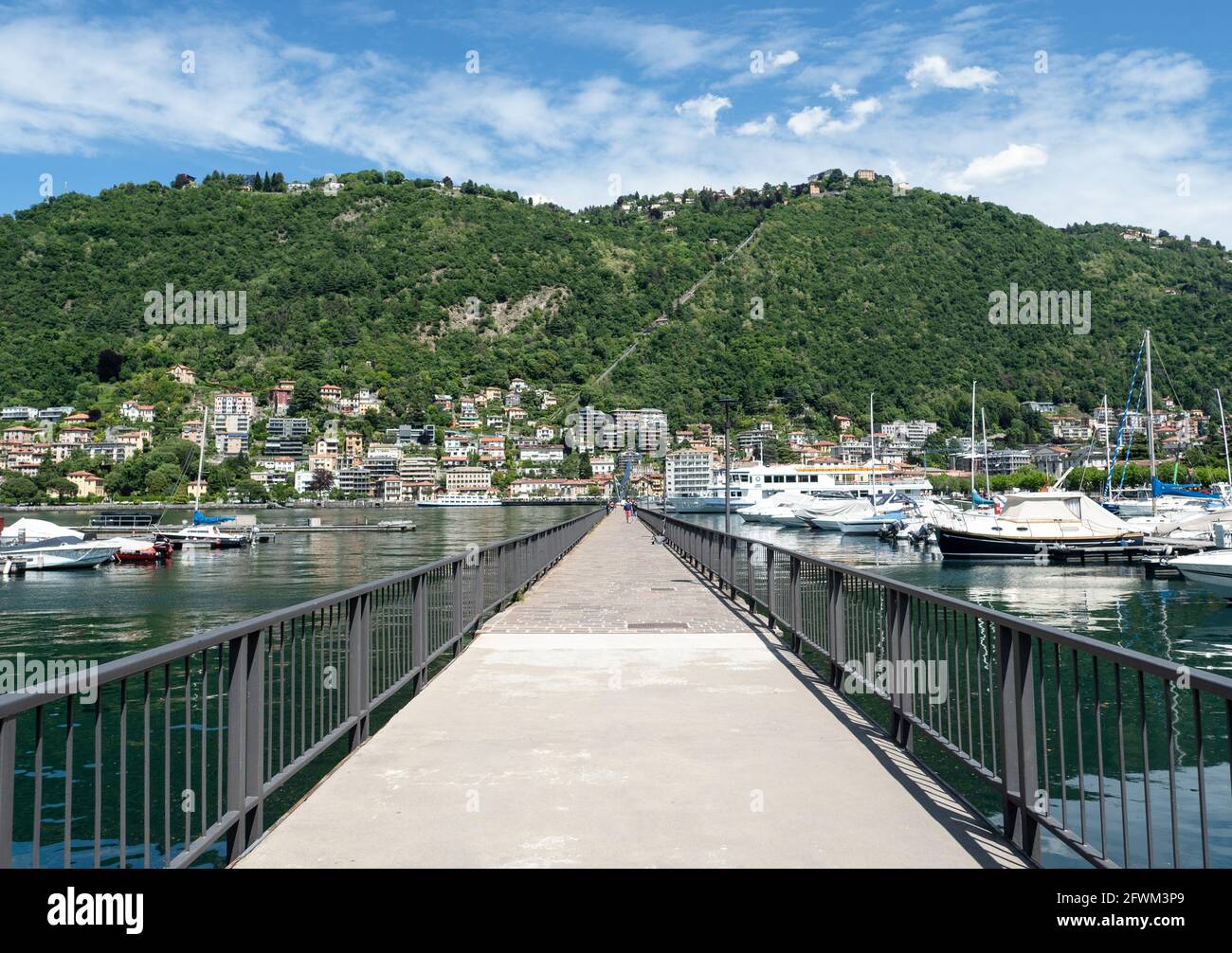 pedestrian walkway crosses the port of como, in the background the ...