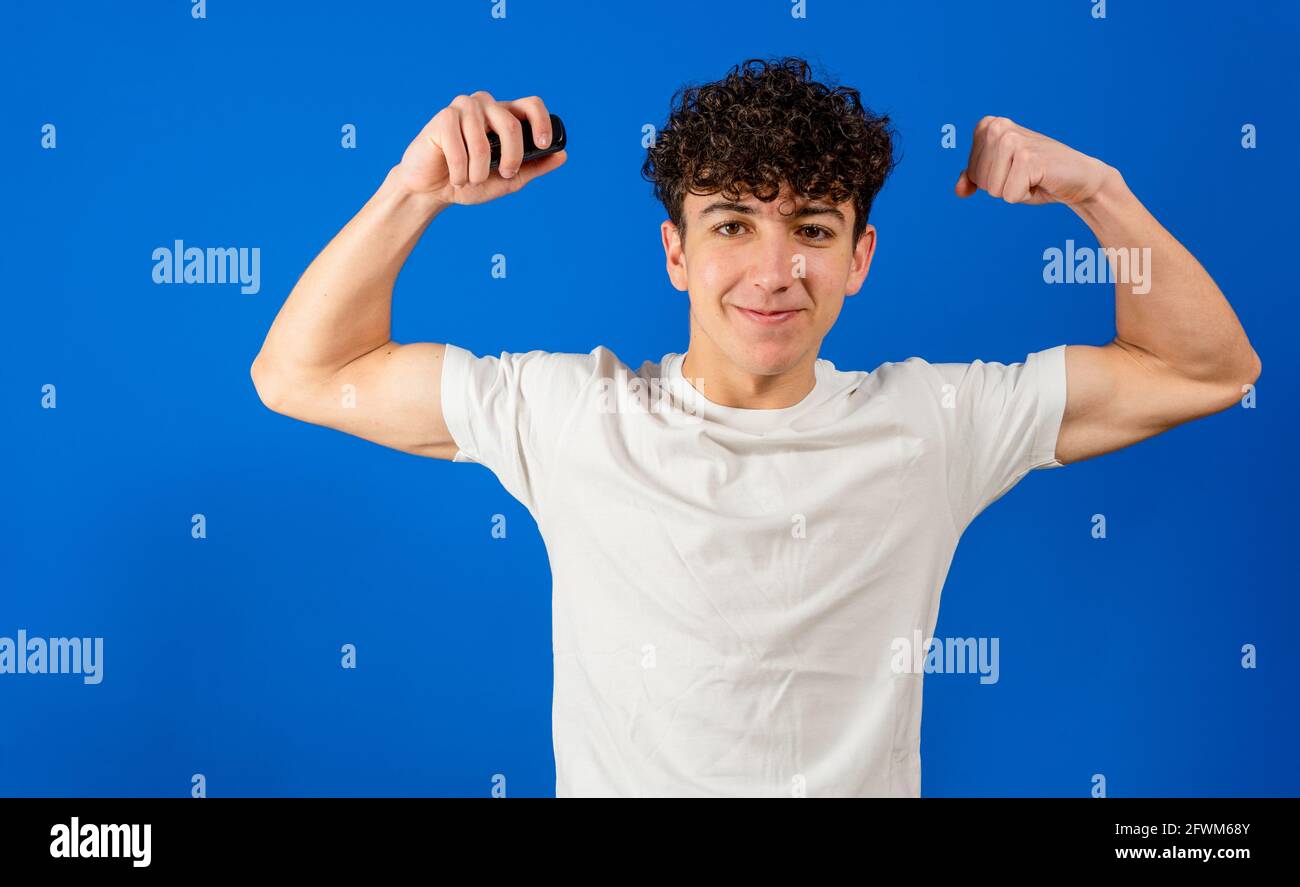 Attractive young man pulling out muscles while looking smiling at the ...