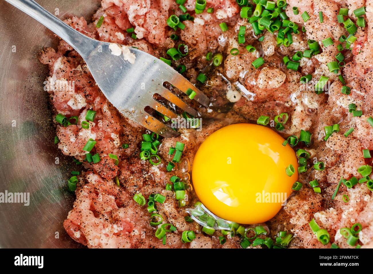Mixing meat and eggs to prepare the meatballs. Dinner cooking Stock ...