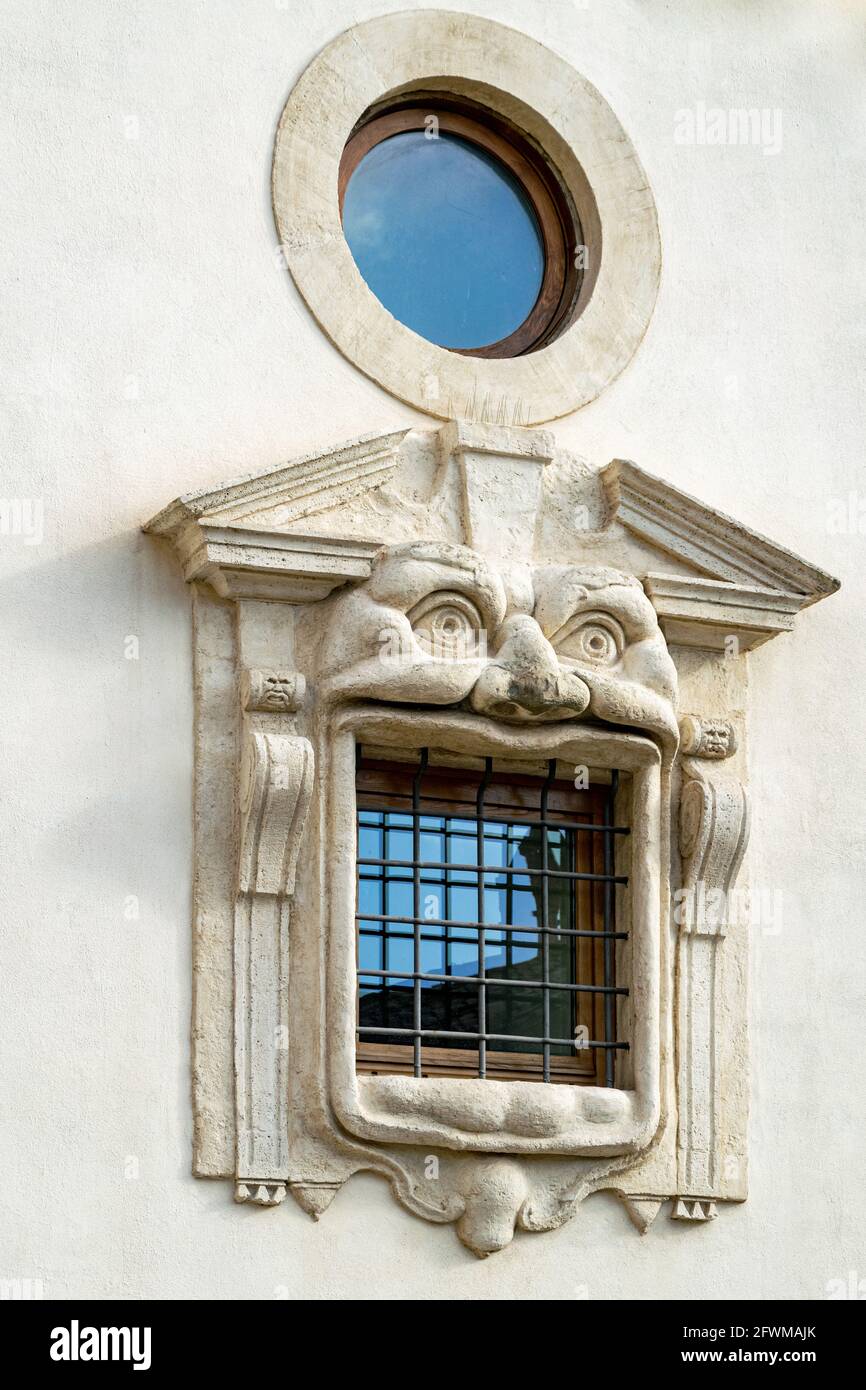 a window frame in the shape of a face with a open mouth as the window ...