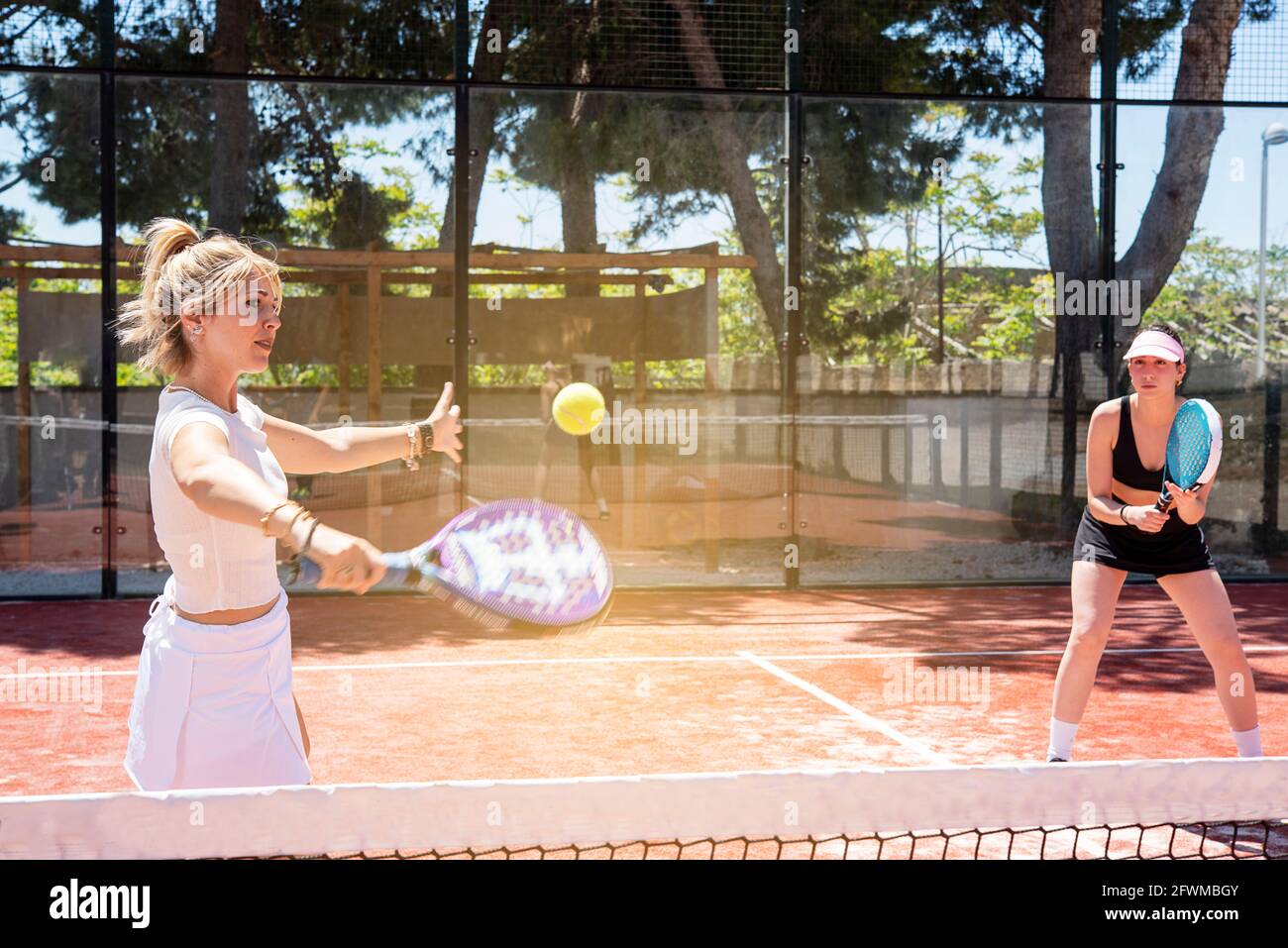 woman smashing in paddle tennis action. Training Basket balls in ...