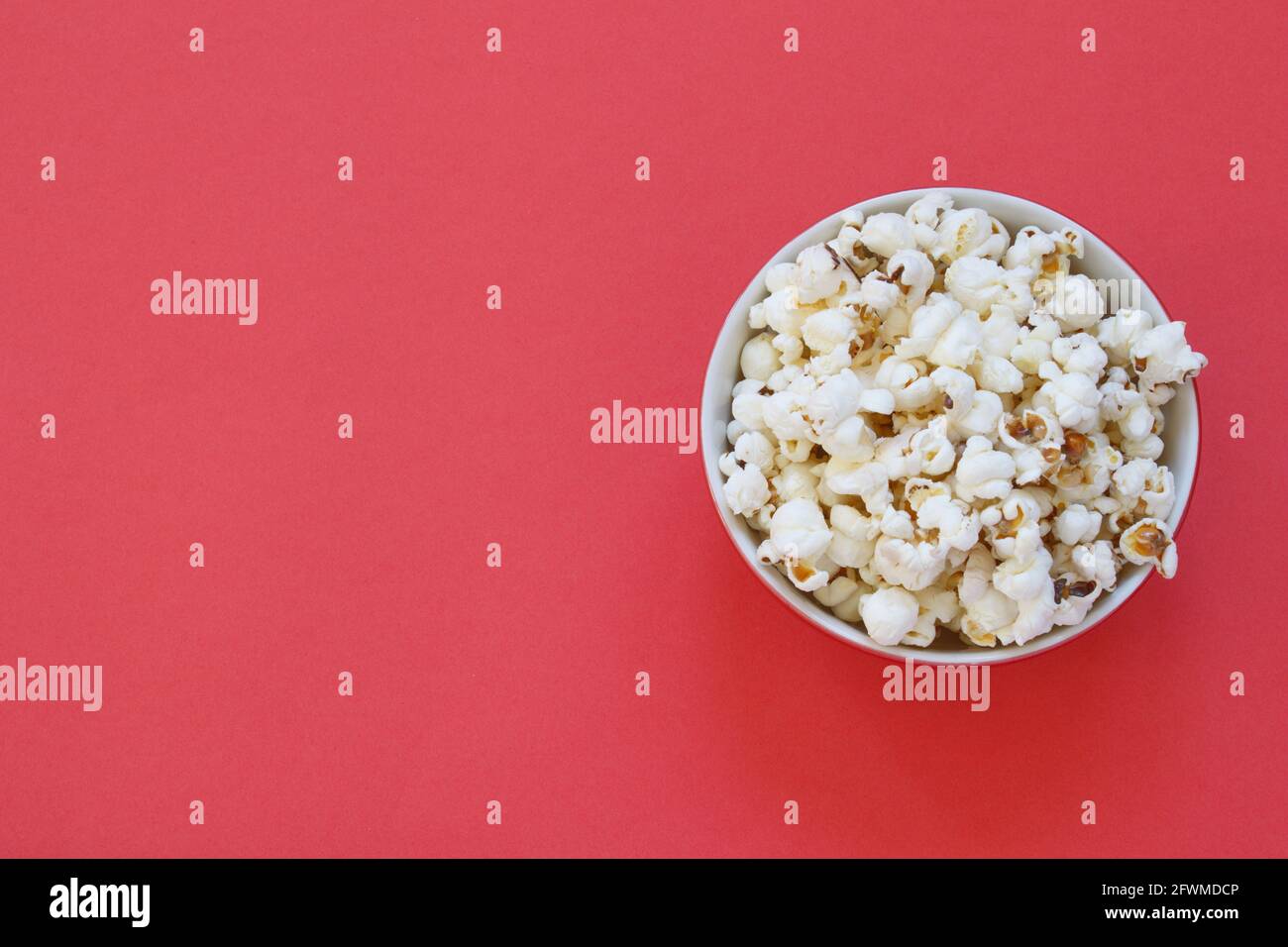 Bowl of popcorn isolated on red background. Movie time. Entertainment ...