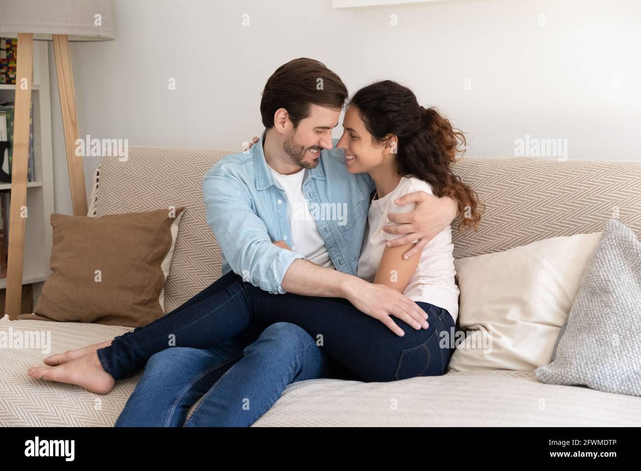 Happy affectionate bonding family couple cuddling sitting on ...