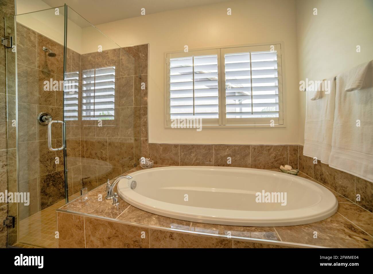 A luxury bathroom interior design with marble brown tiles and a window ...