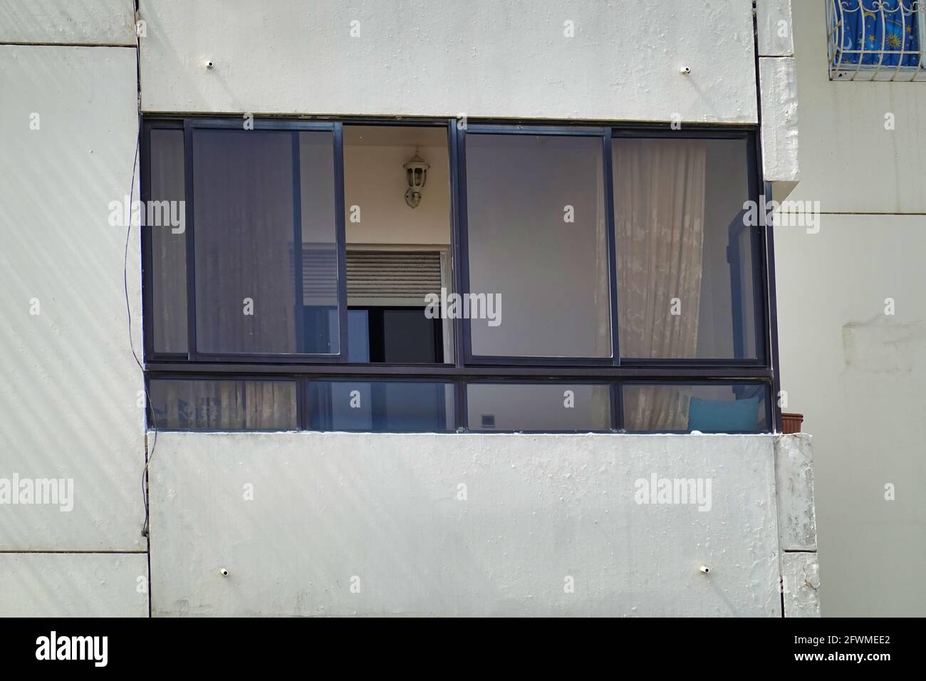A sliding glass window on a white wall building Stock Photo - Alamy