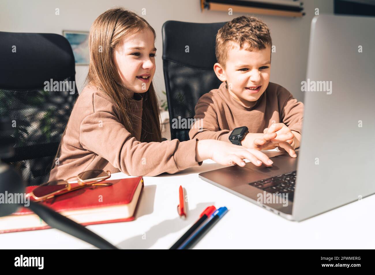 Little boy and girl study online in home at the laptop Stock Photo - Alamy