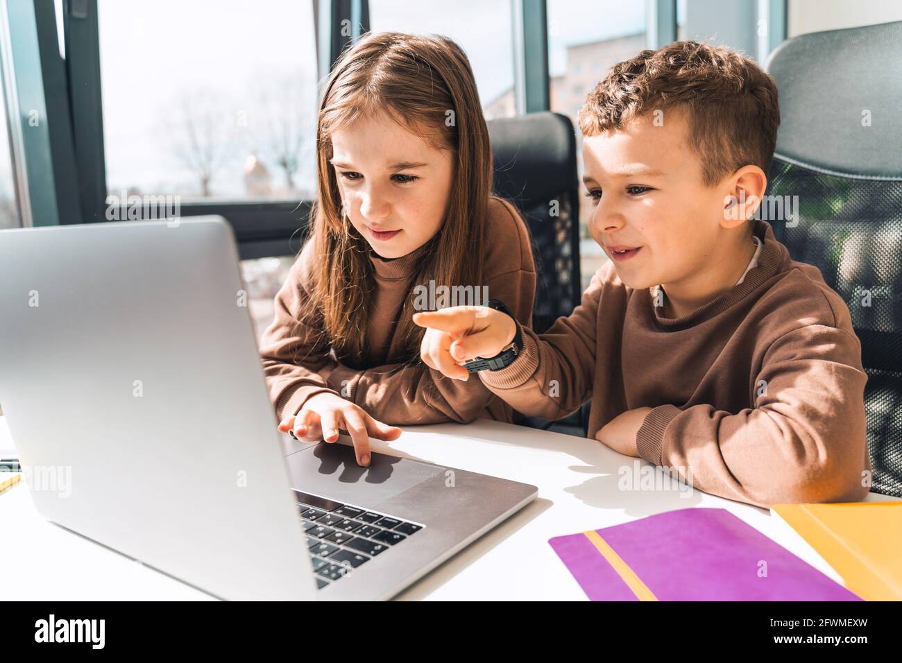 Cute siblings using laptop hi-res stock photography and images - Alamy