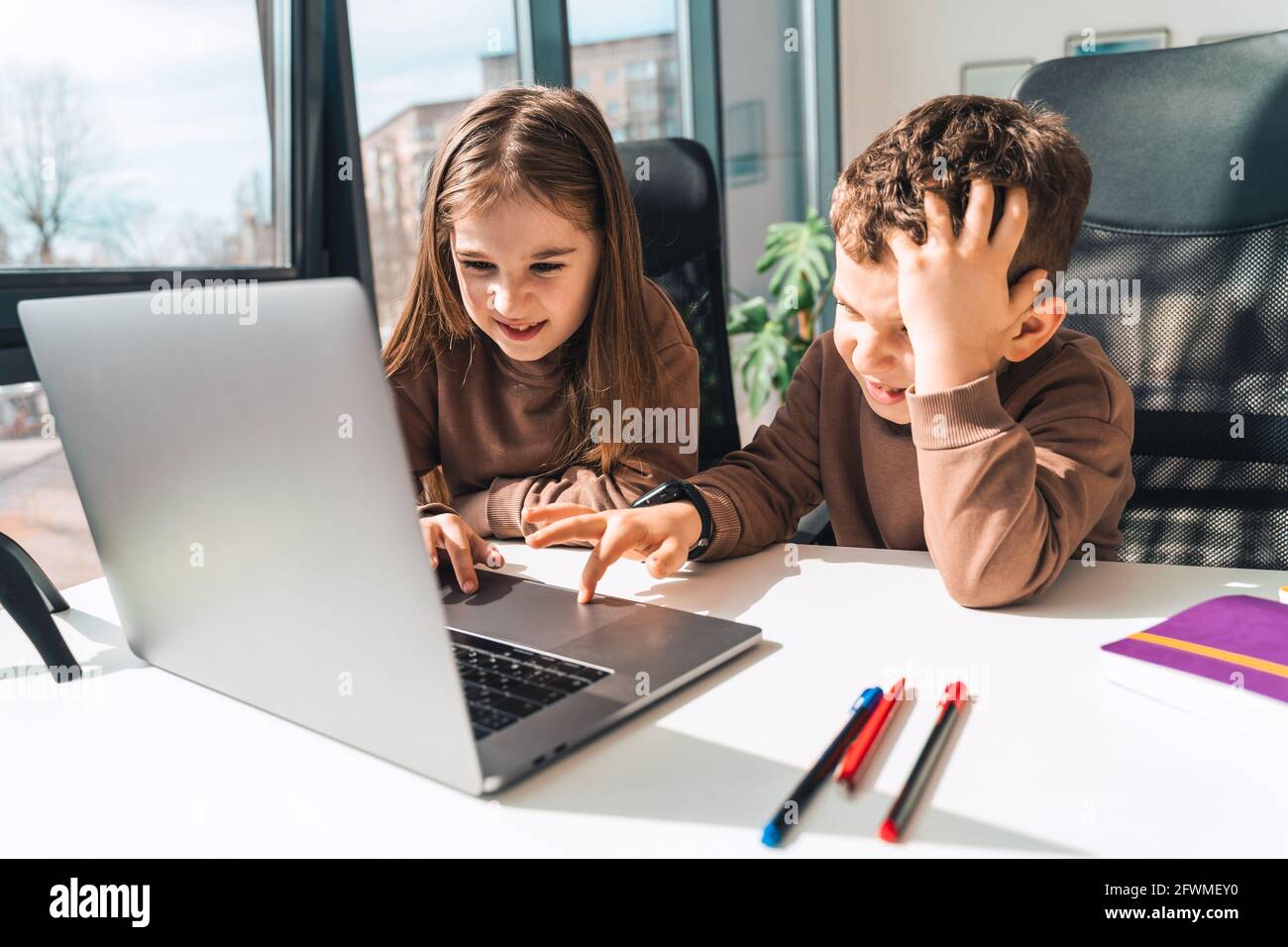 Cute siblings using laptop hi-res stock photography and images - Alamy