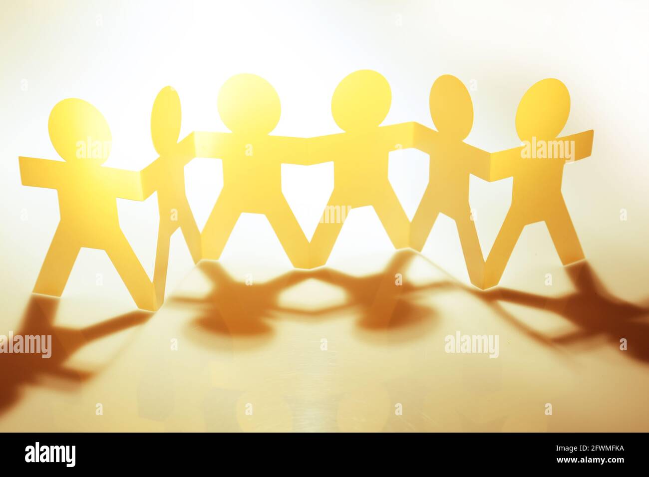 Paper chain team holding hands. Teamwork. Partnership Stock Photo - Alamy
