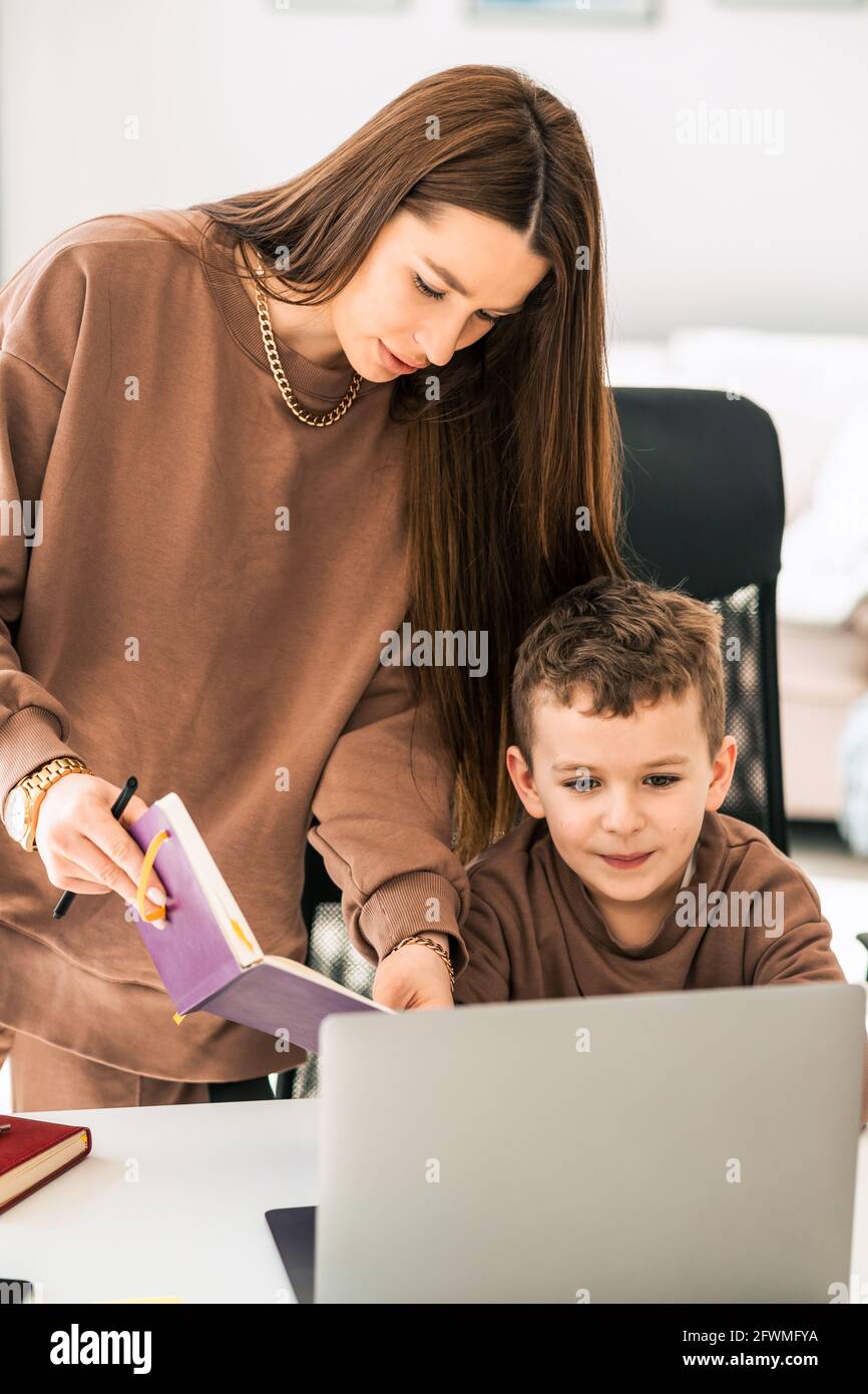 Mother helps the child to study. Woman teaching boy at home Stock Photo ...
