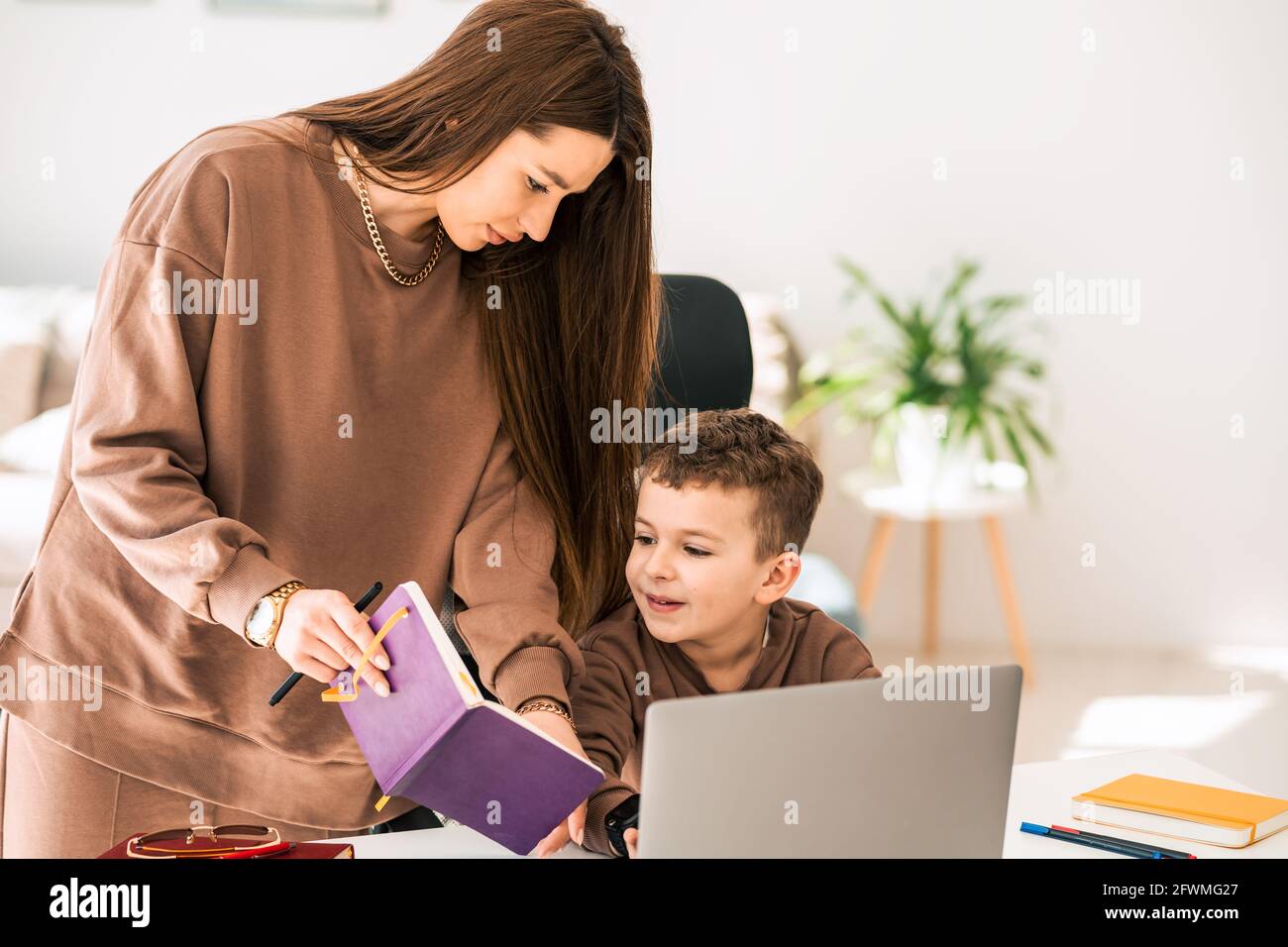 Mom helps son with homework. Distance education Stock Photo - Alamy