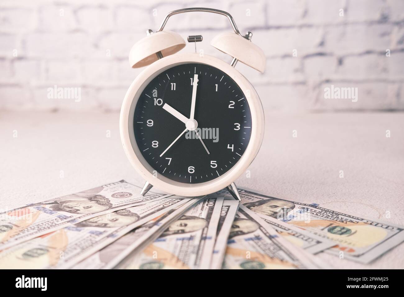 Close up of 100 dollar cash and old alarm clock on table Stock Photo ...