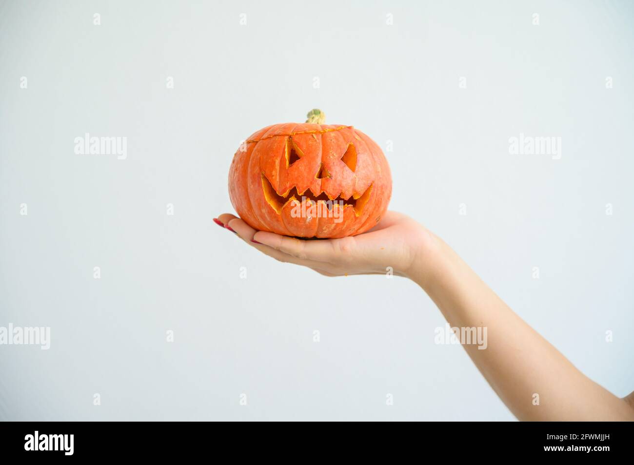 Female hand holding a pumpkin for Halloween. Close-up jack-o'-lantern ...