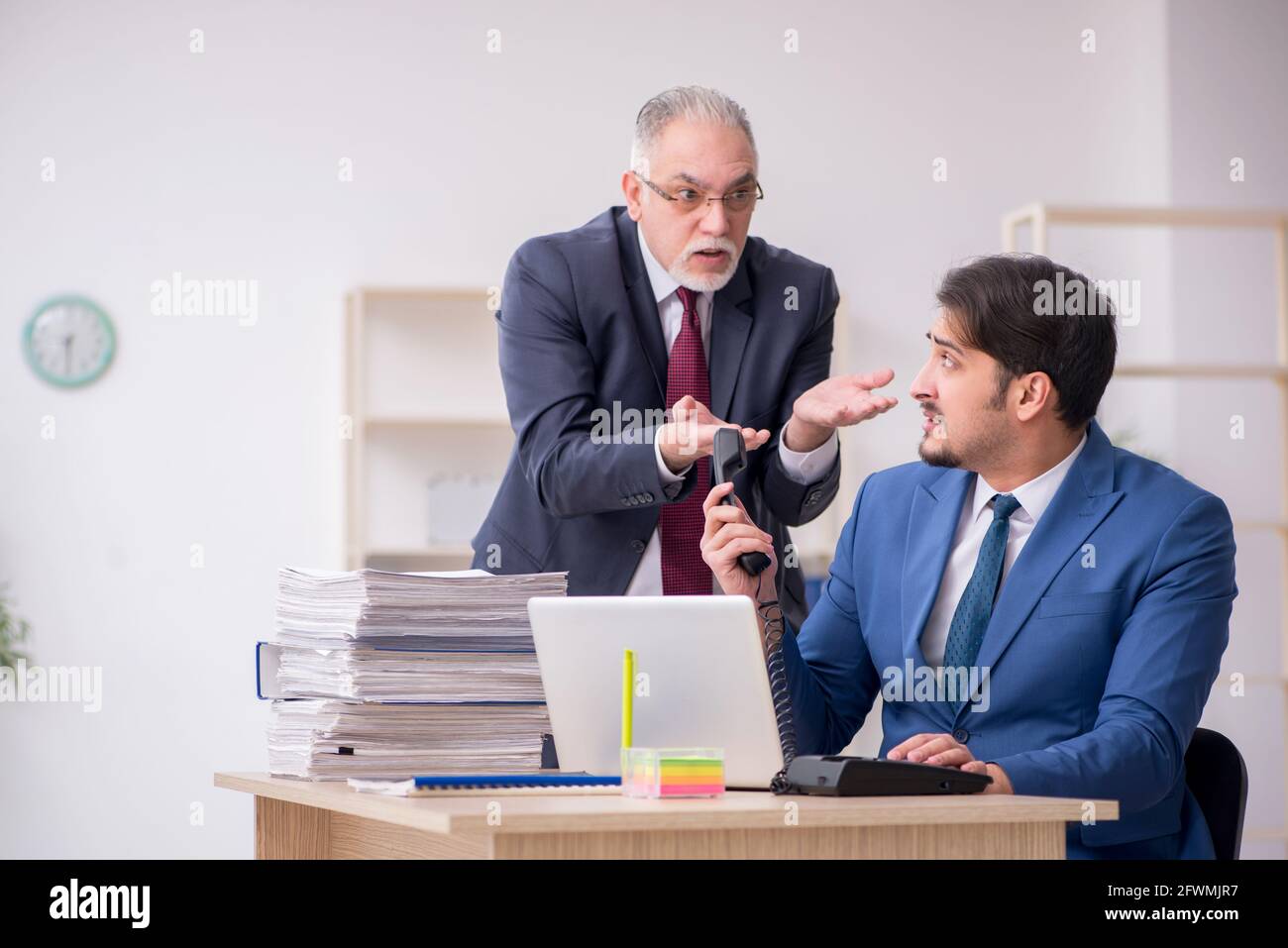 Old boss and young employee working in the office Stock Photo - Alamy