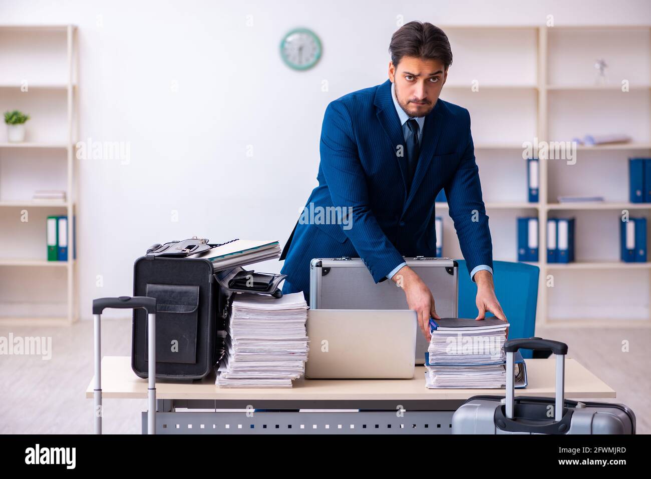 Young businessman employee preparing for business trip at workplace ...