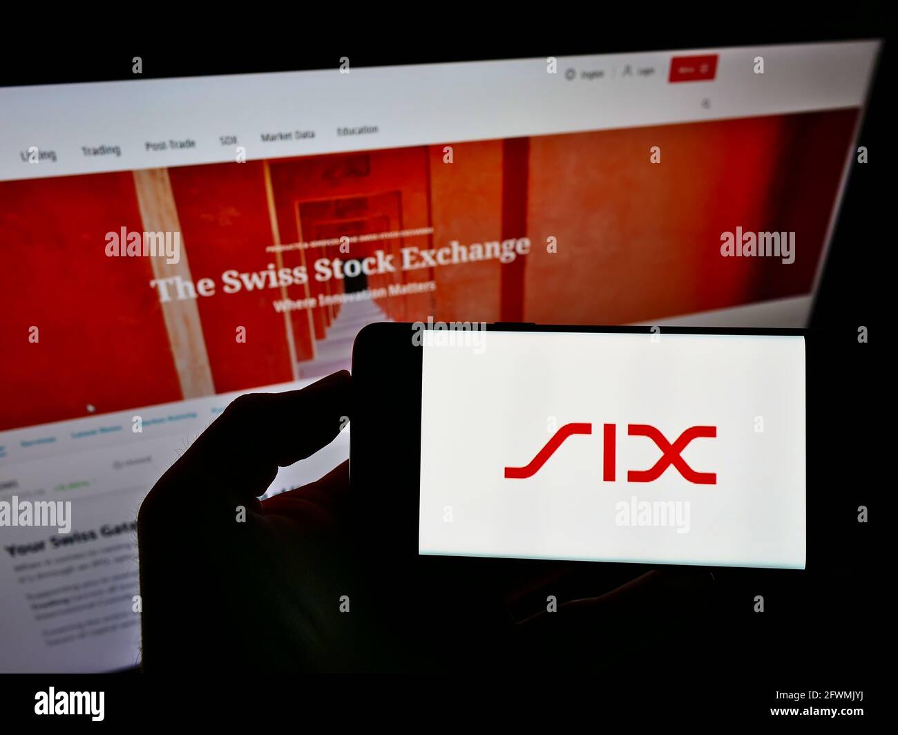 Person holding cellphone with business logo of Swiss financial services ...