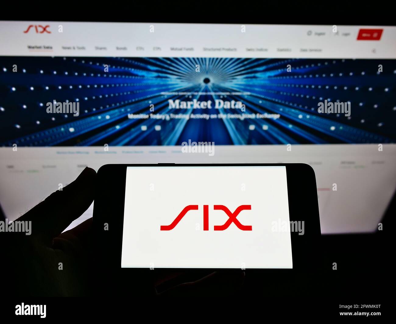 Person holding mobile phone with logo of Swiss financial services ...