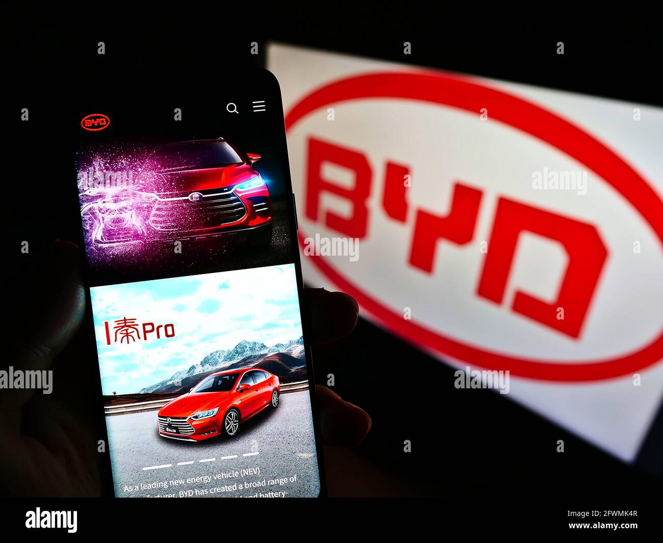 Person holding cellphone with webpage of Chinese car manufacturer BYD ...