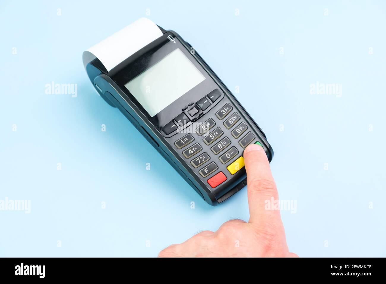 Man hand pushing a button on POS terminal with roll paper cash tape on ...