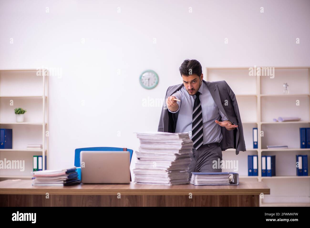Funny young employee magician and too much work in the office Stock ...