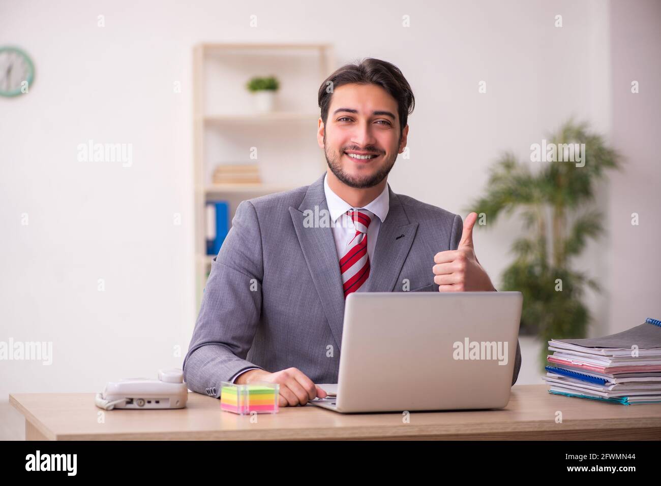 Young male employee working at workplace Stock Photo - Alamy