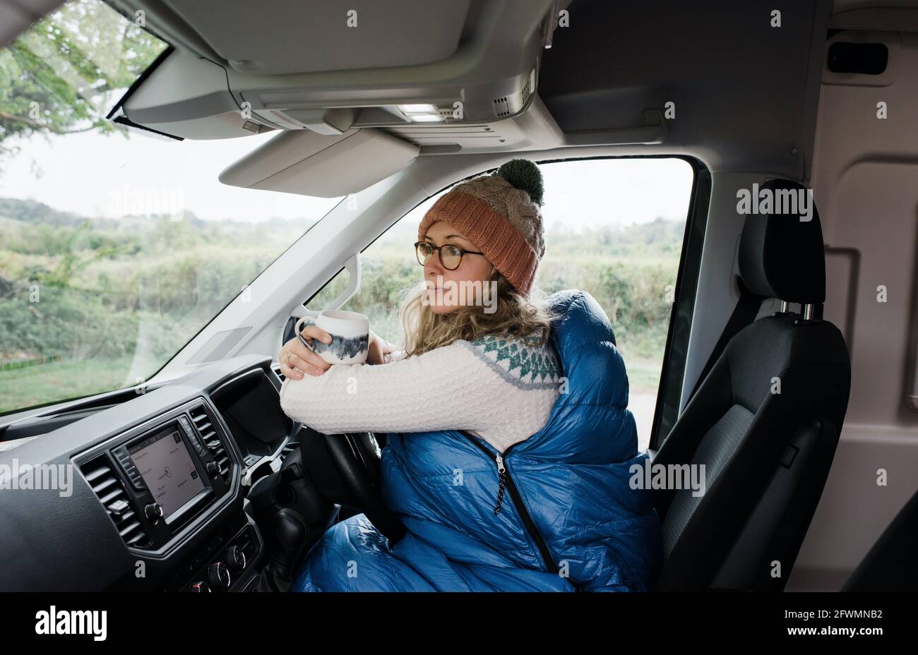 woman sat in camper van enjoying a cup of tea in the morning Stock ...