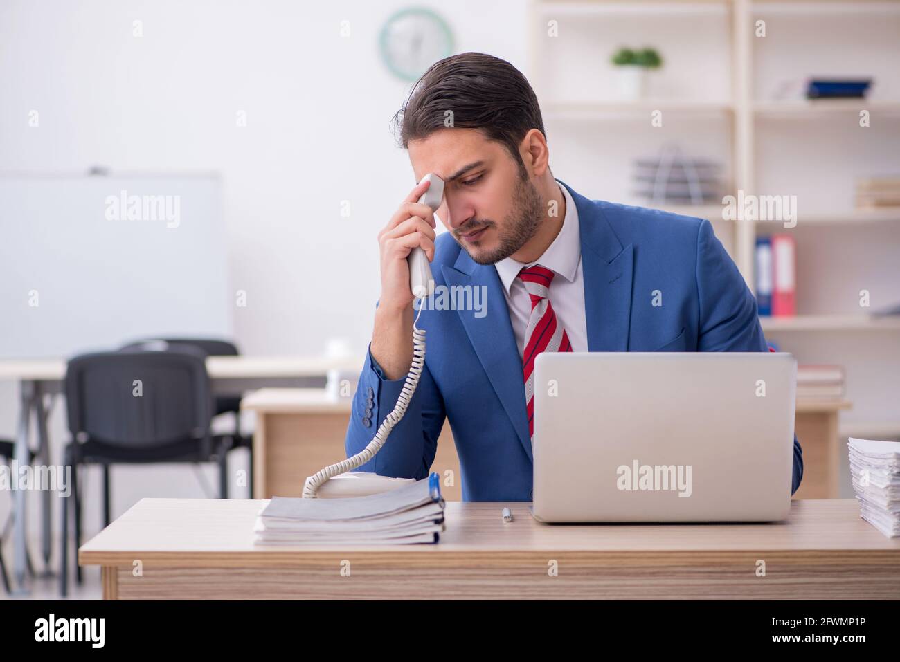 Young male employee working in the office Stock Photo - Alamy