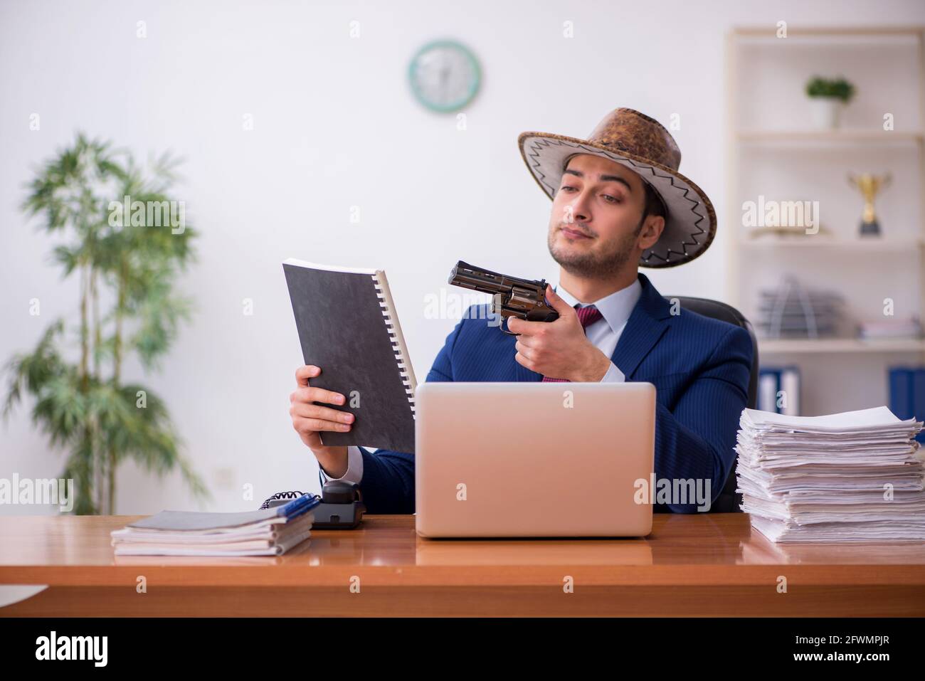 Young cowboy employee working at workplace Stock Photo - Alamy