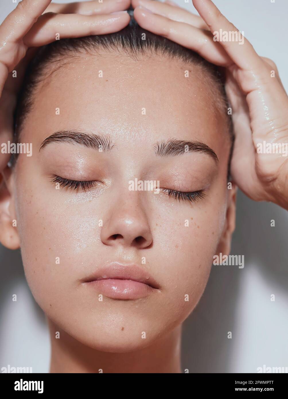 Young beautiful woman with clean fresh skin with splash of water ...