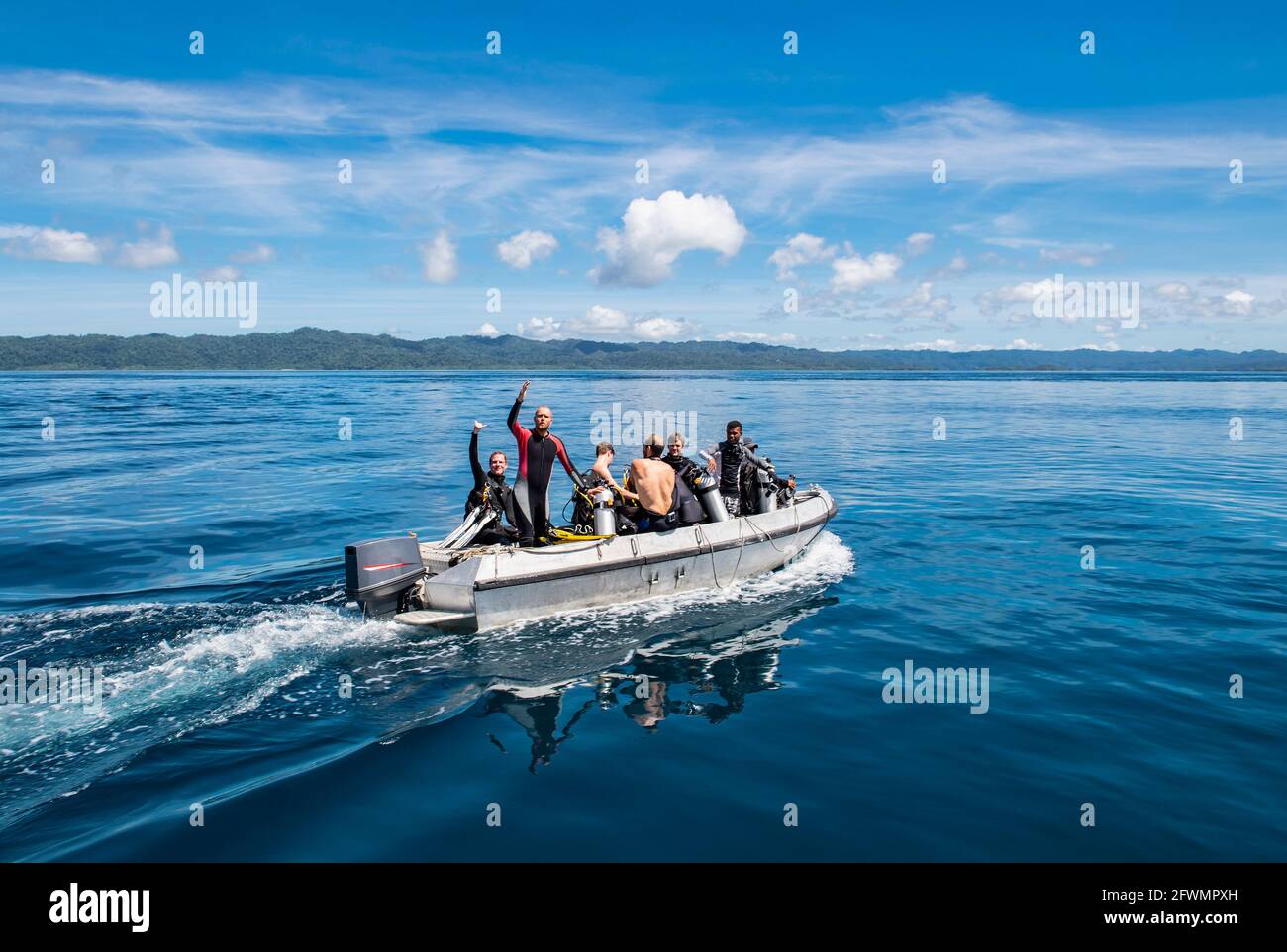 divers heading to dive spot on dingy boat in Raja Ampat Stock Photo - Alamy