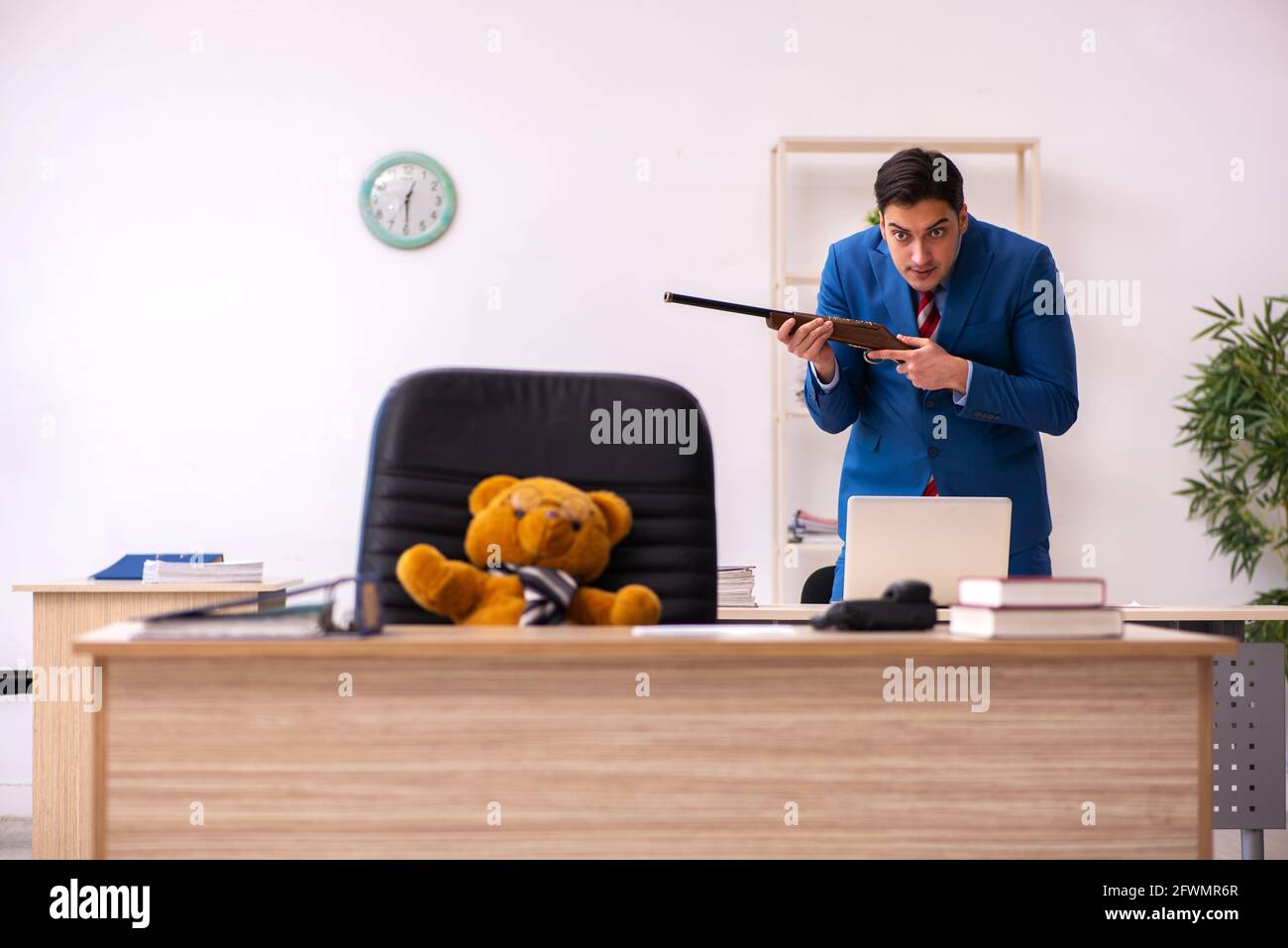 Young employee and his toy bear boss in funny concept Stock Photo - Alamy