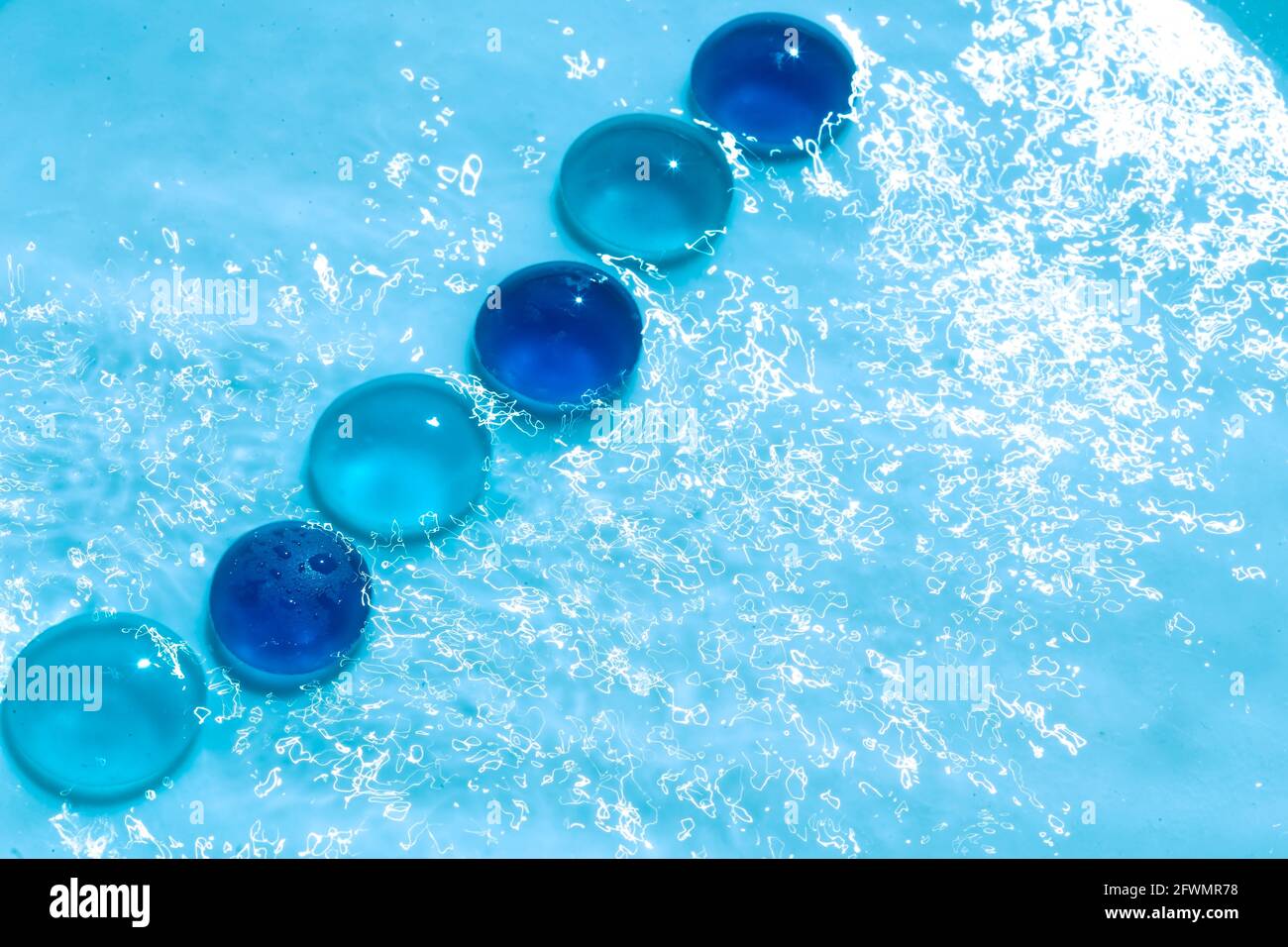 Marbles in the blue water Stock Photo - Alamy