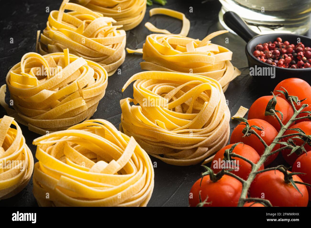 Pasta tagliatelle with ingredients set, on black stone background Stock ...