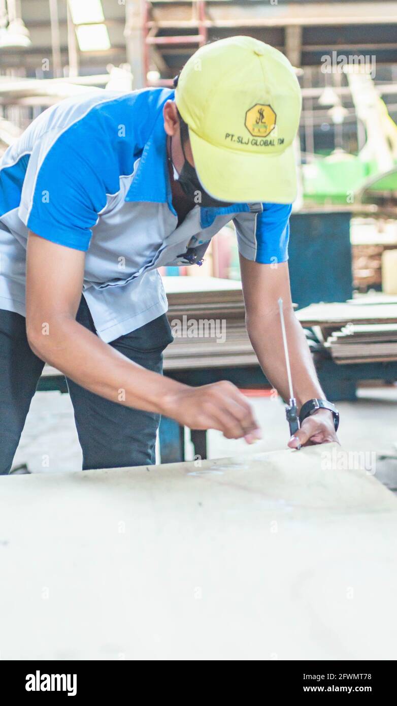 A worker doing final quality inspection at plywood manufacture factory ...