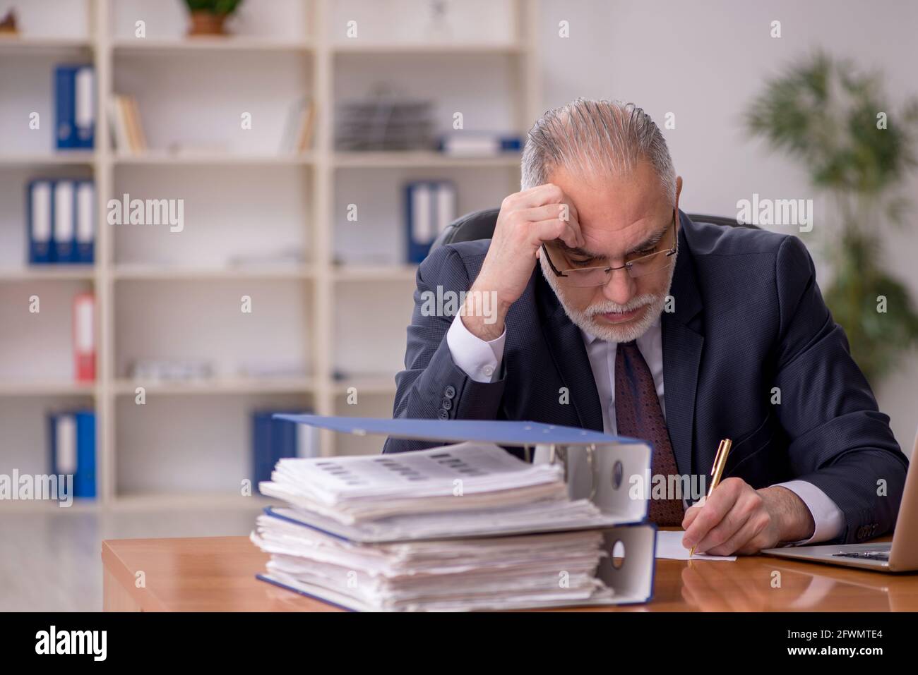 Old male employer and too much work at workplace Stock Photo - Alamy