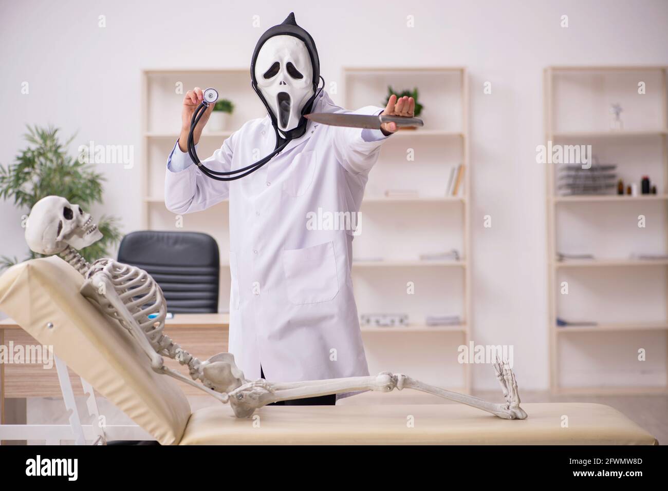 Devil doctor examining skeleton patient in the clinic Stock Photo - Alamy