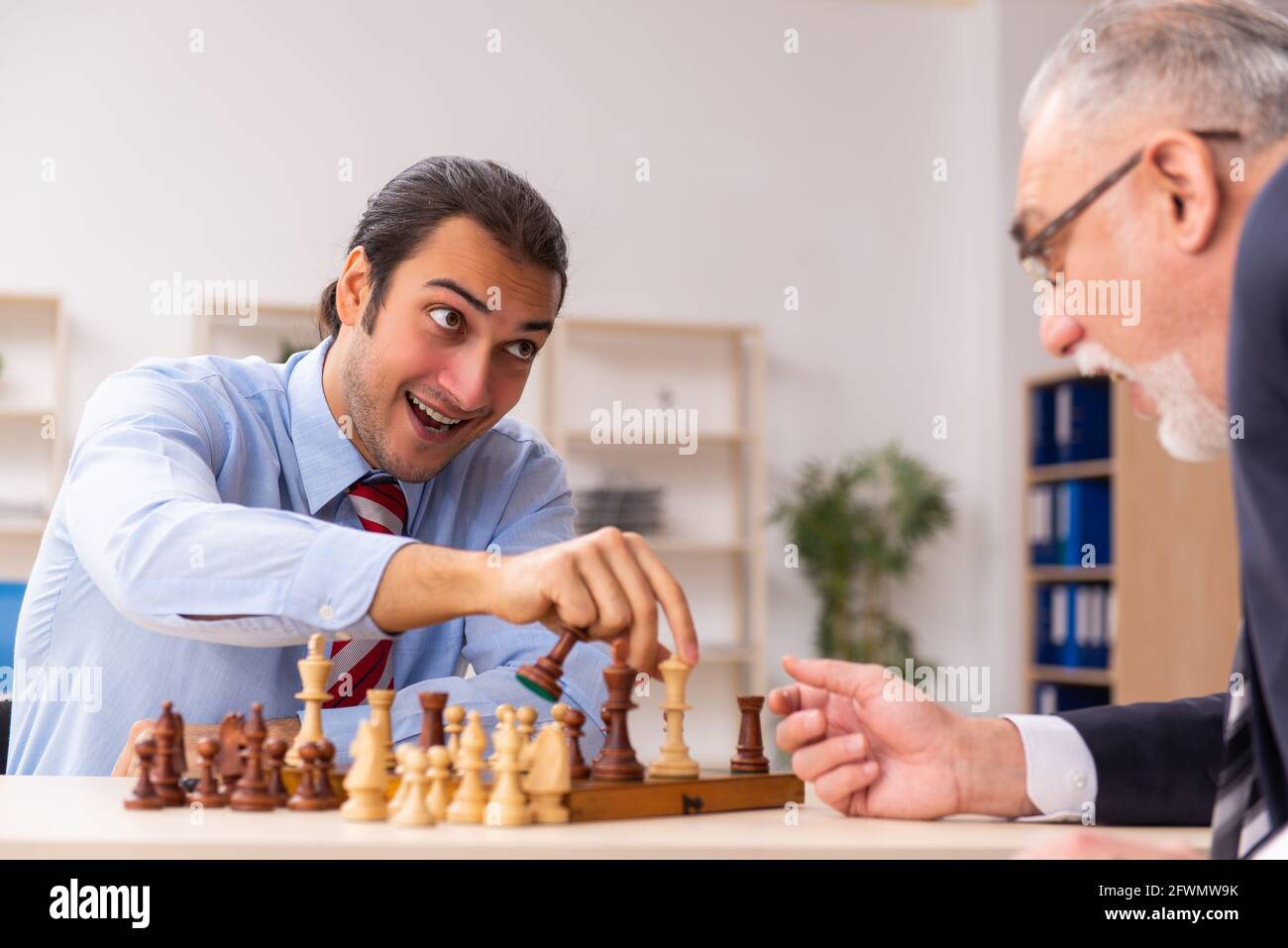 Two male employees playing chess at workplace Stock Photo - Alamy