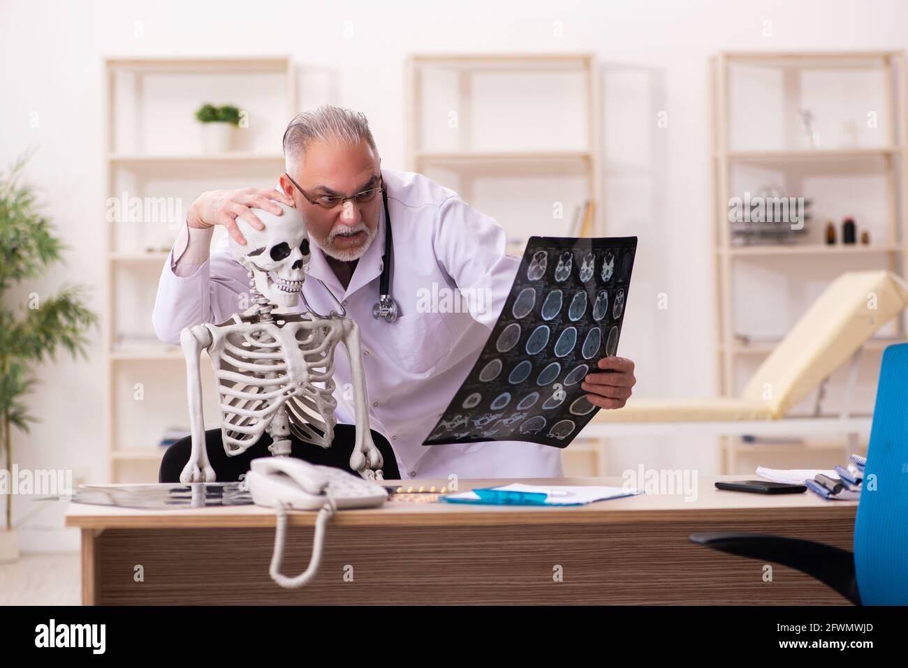 Skeleton patient visiting old male doctor radiologist Stock Photo - Alamy