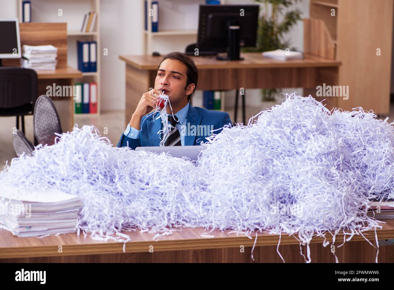 Young businessman employee and a lot of cut papers in the office Stock ...