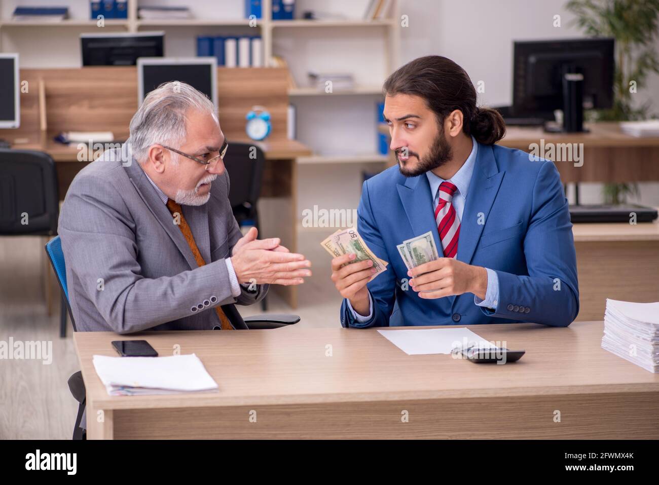 Two employees in remuneration concept Stock Photo - Alamy