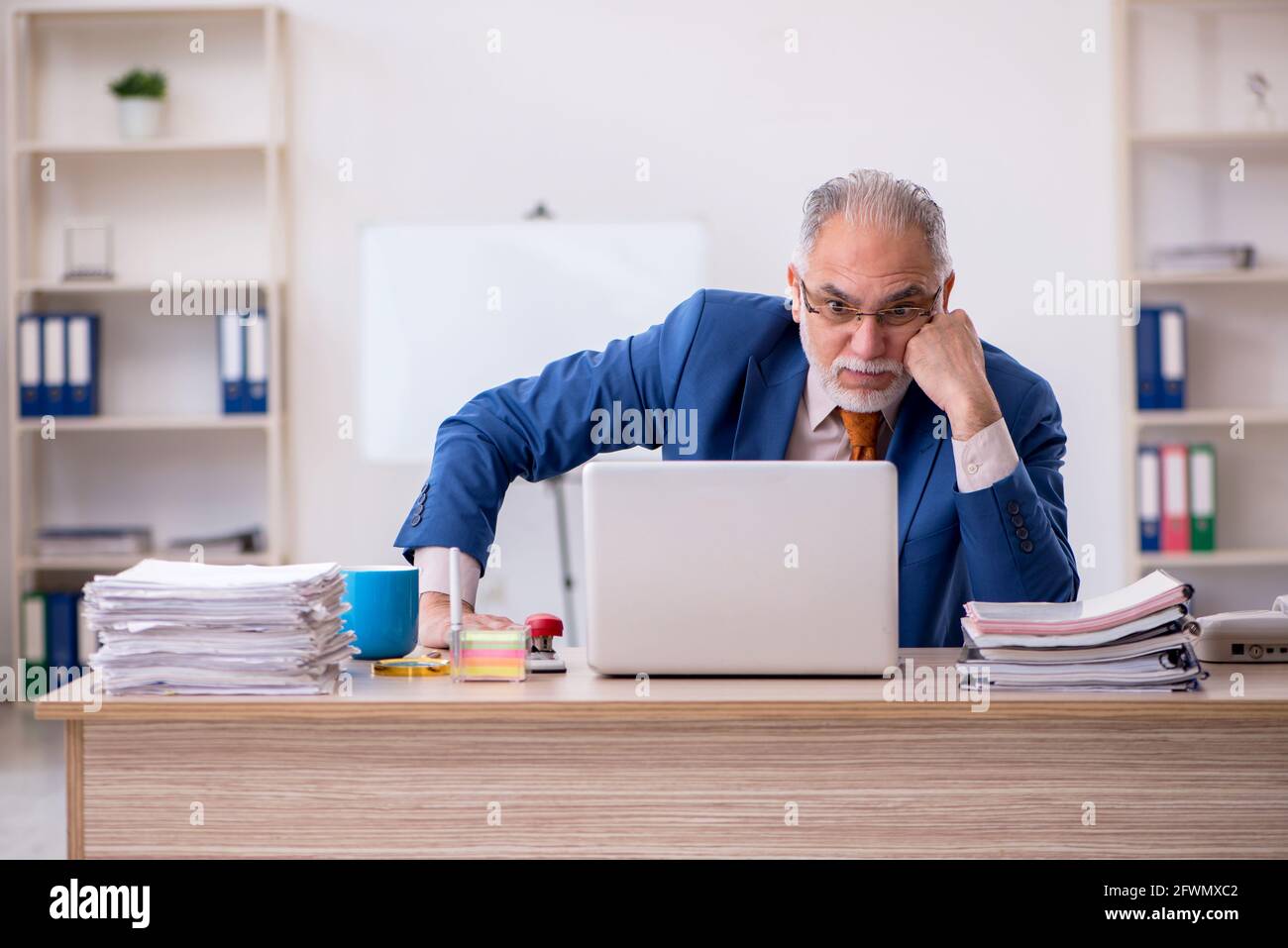 Old businessman employee sitting at workplace Stock Photo - Alamy